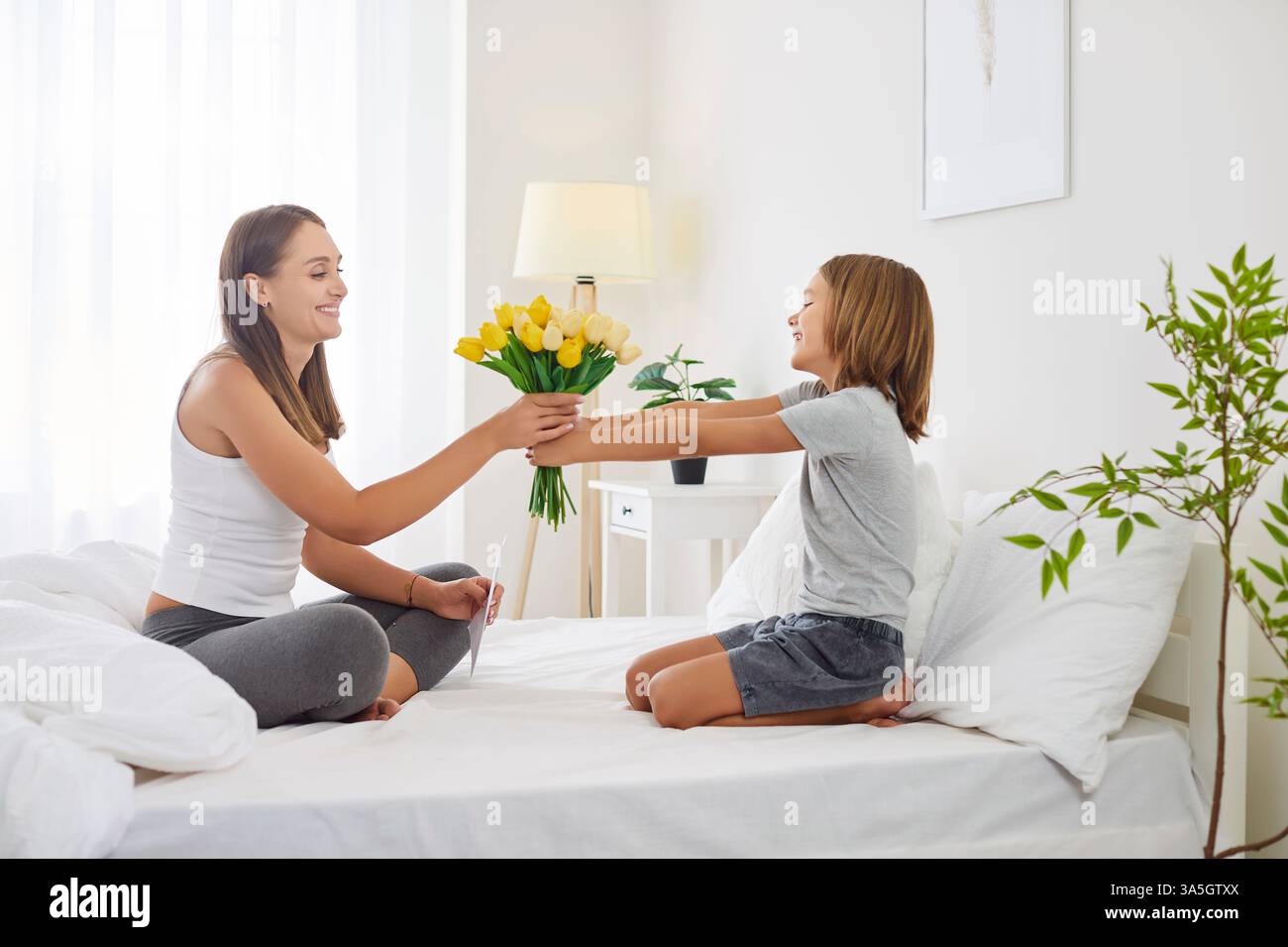 Happy Mothers Day holiday morning, joyful mum and son giving flowers ...
