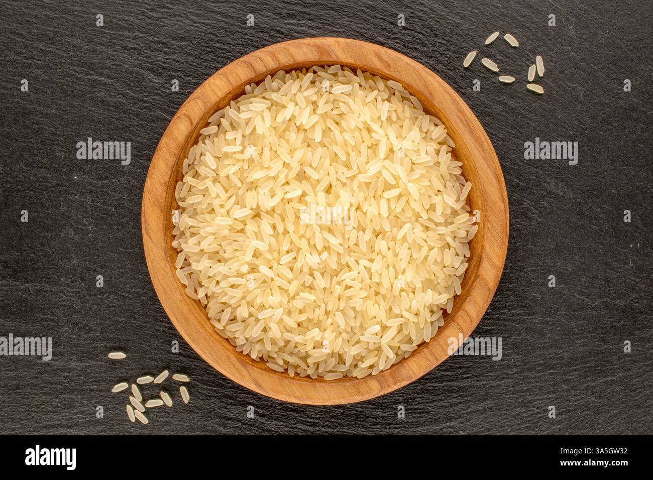 Steamed raw rice with wooden plate on slate stone, close-up, top view ...