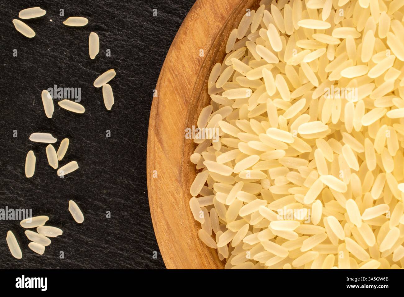 Steamed raw rice with wooden plate on slate stone, close-up, top view ...