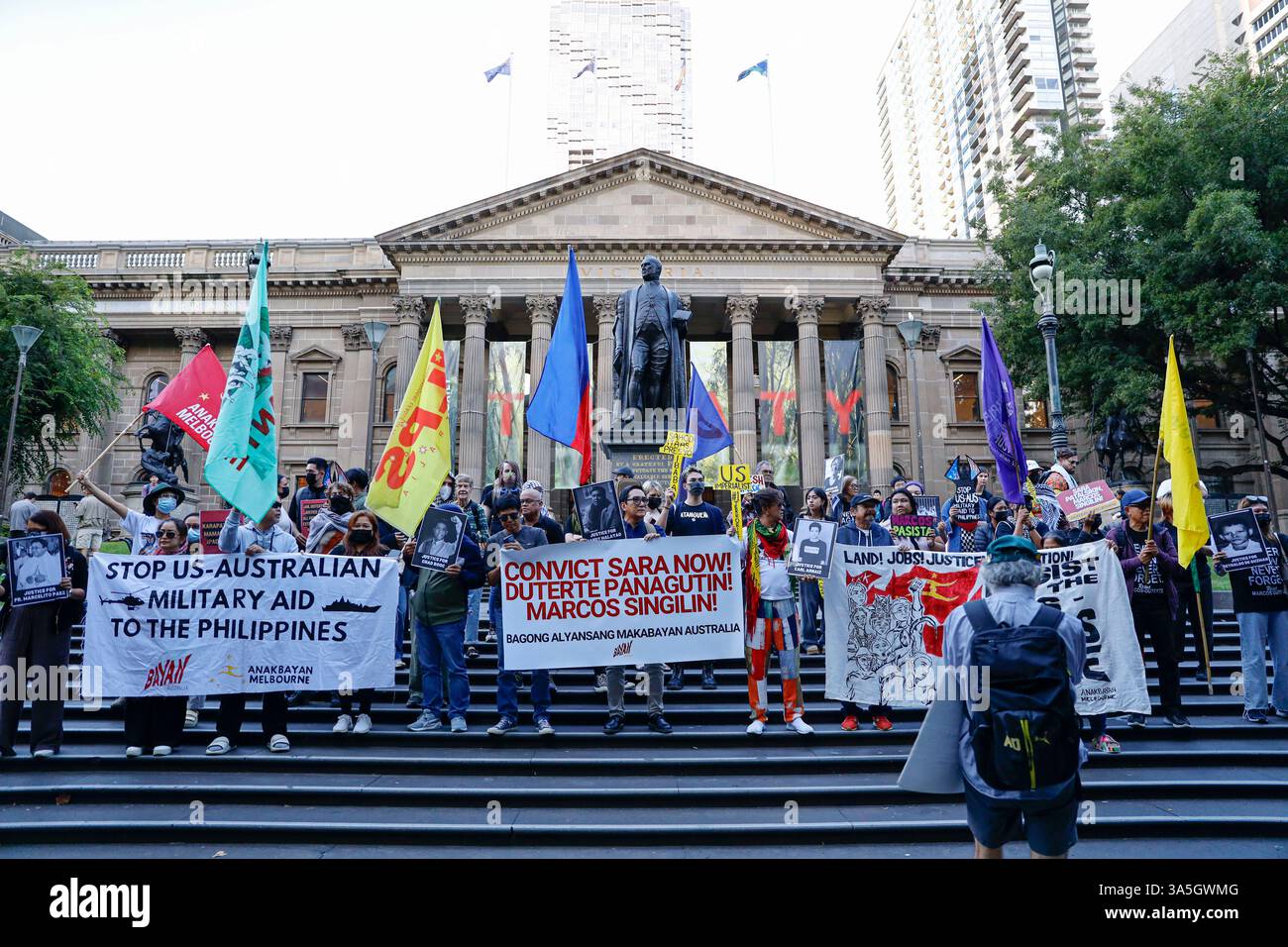 Community members hold a banners during the rally. A rally in Melbourne ...