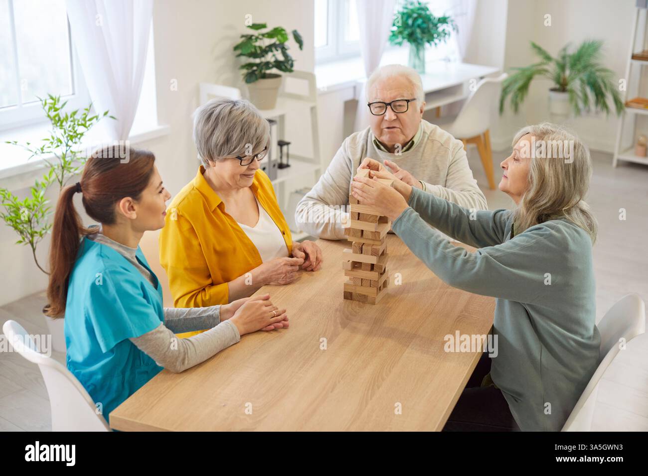 Seniors playing with wooden building blocks for dementia therapy in ...