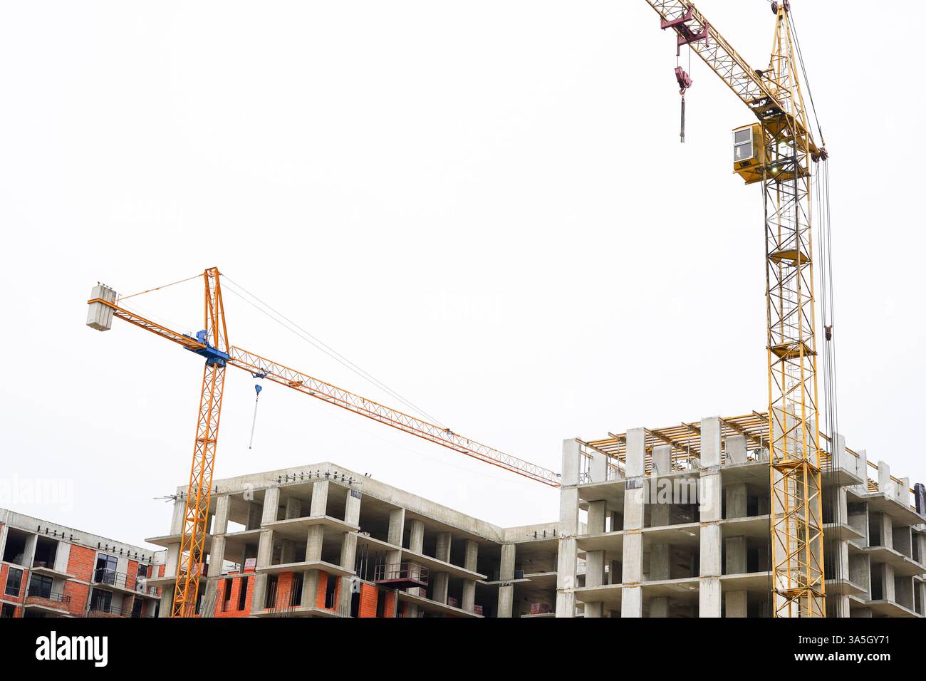 a construction site with two tall cranes working on a multi-story ...