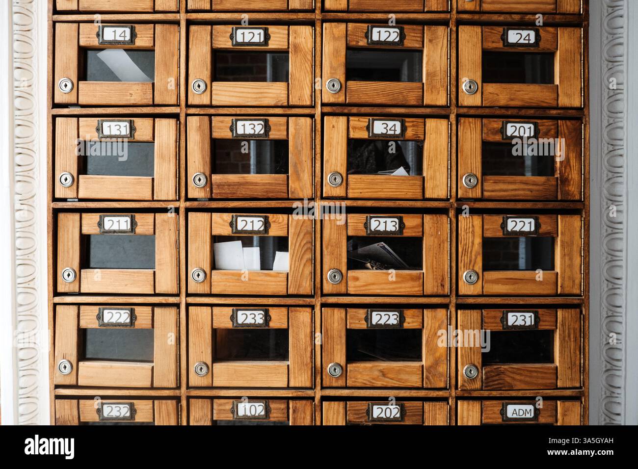 Vintage wooden mailbox wall with numbered glass-front compartments ...