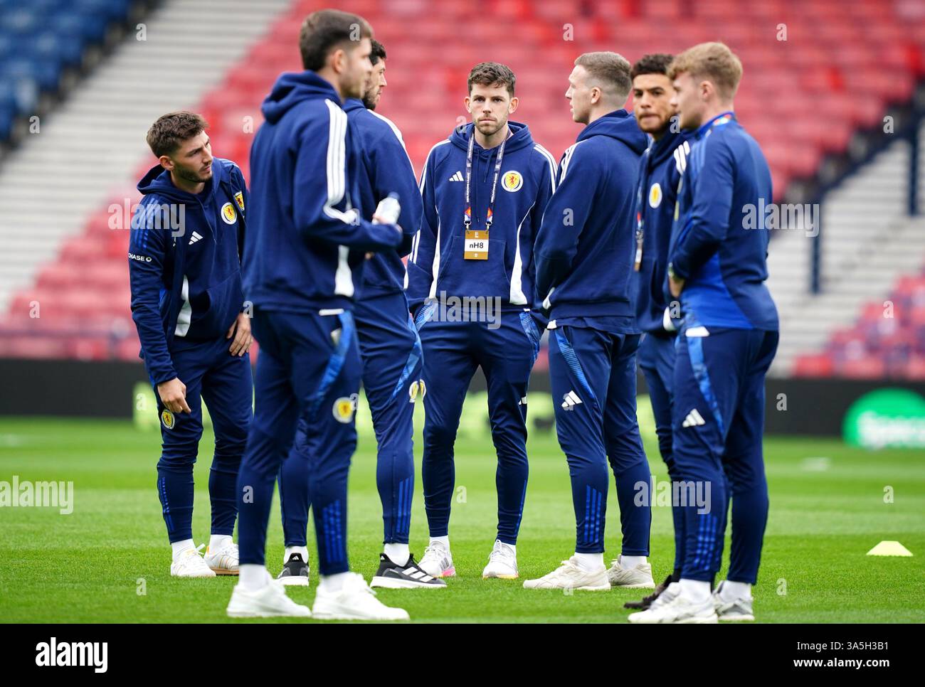 Scotland's Ryan Christie (centre) and team-mates inspect the pitch ...