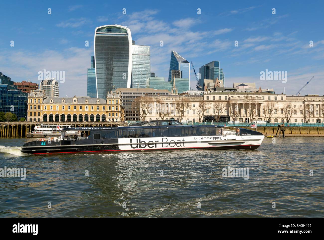 Uber clipper boat passing Custom House building contrast with modern ...