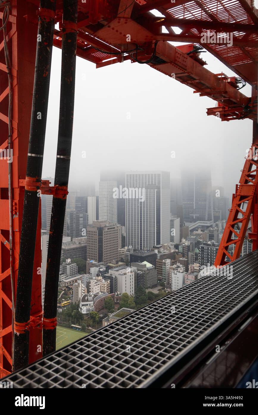 Looking through the framework of Tokyo Tower at the misty cityscape ...