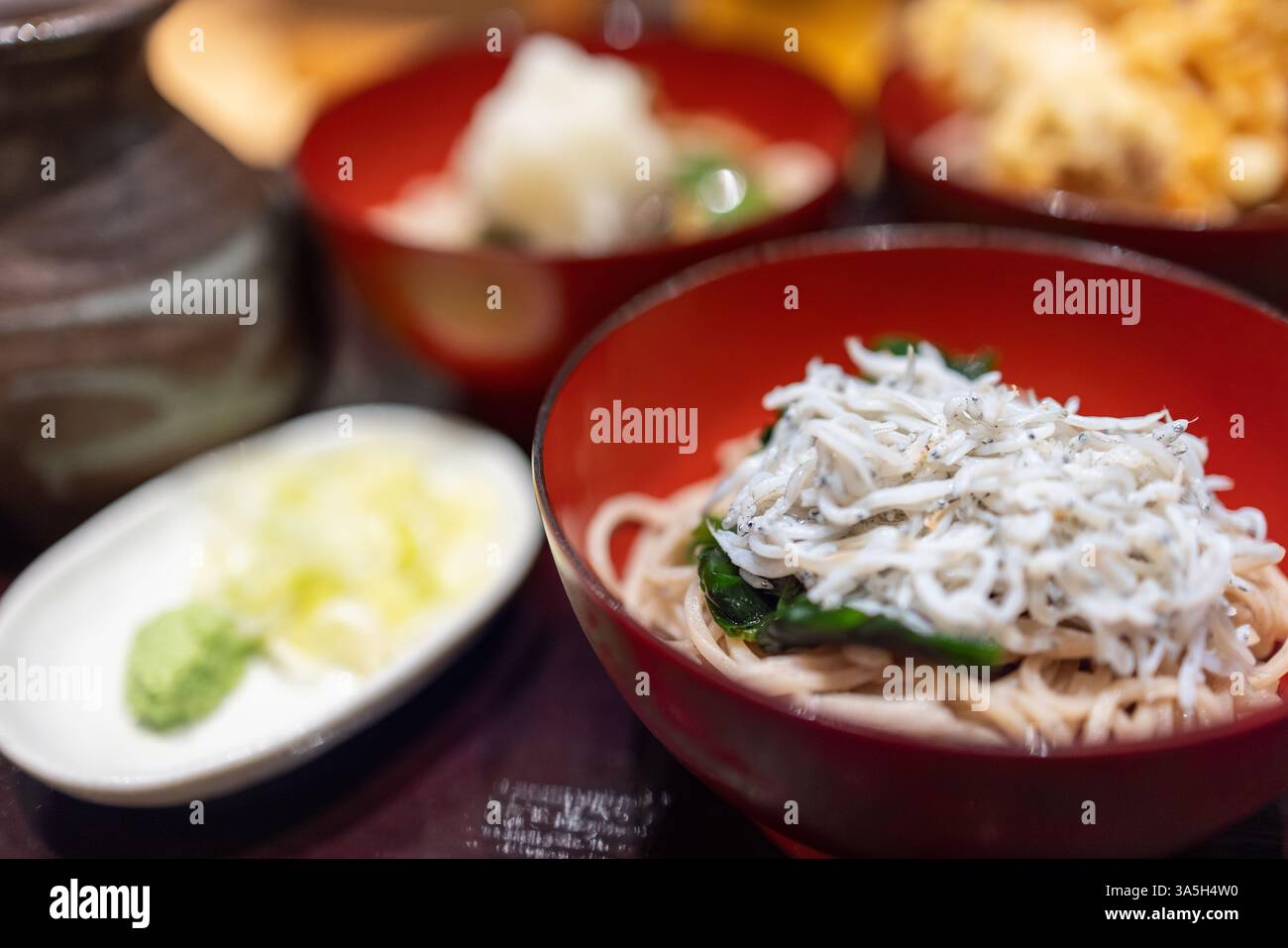 Japanese soba noodle dish garnished with whitebait fish and greens ...