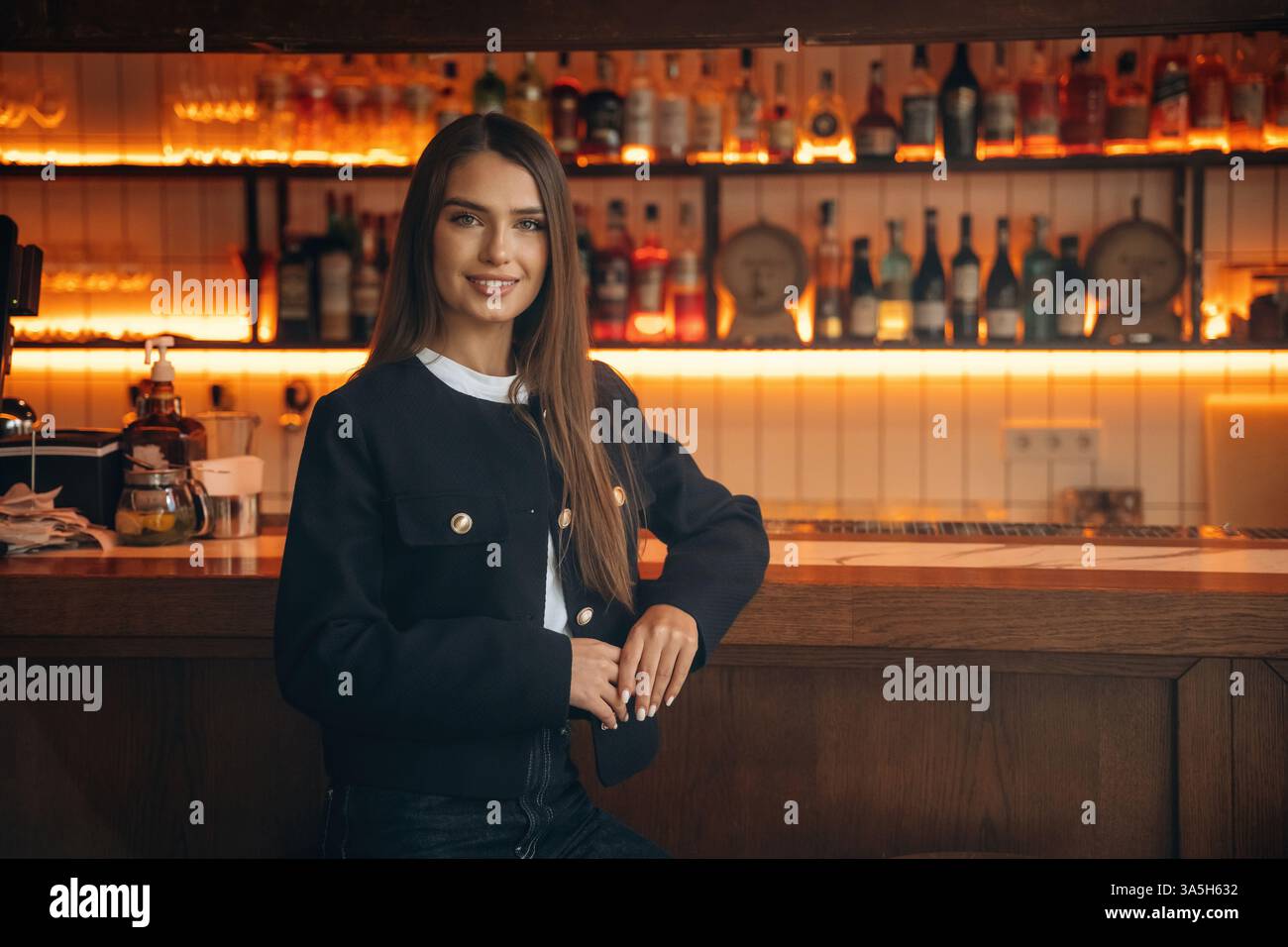 Beautiful woman is standing at the bar and smiling Stock Photo - Alamy