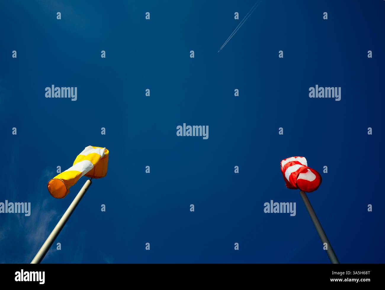 Windstill conditions with two windsocks in yellow and red with white ...