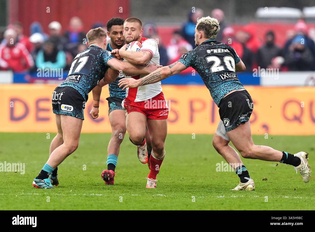 Hull KR's Mikey Lewis (centre) is tackled by Leigh Leopards' Brad Dwyer ...