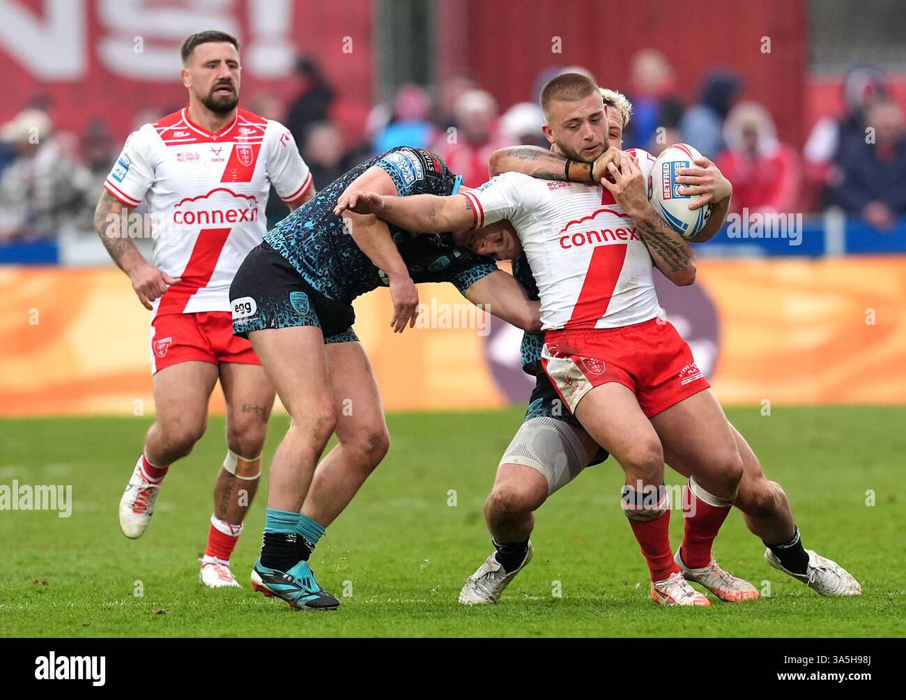 Hull KR's Mikey Lewis (centre) is tackled by Leigh Leopards' Brad Dwyer ...