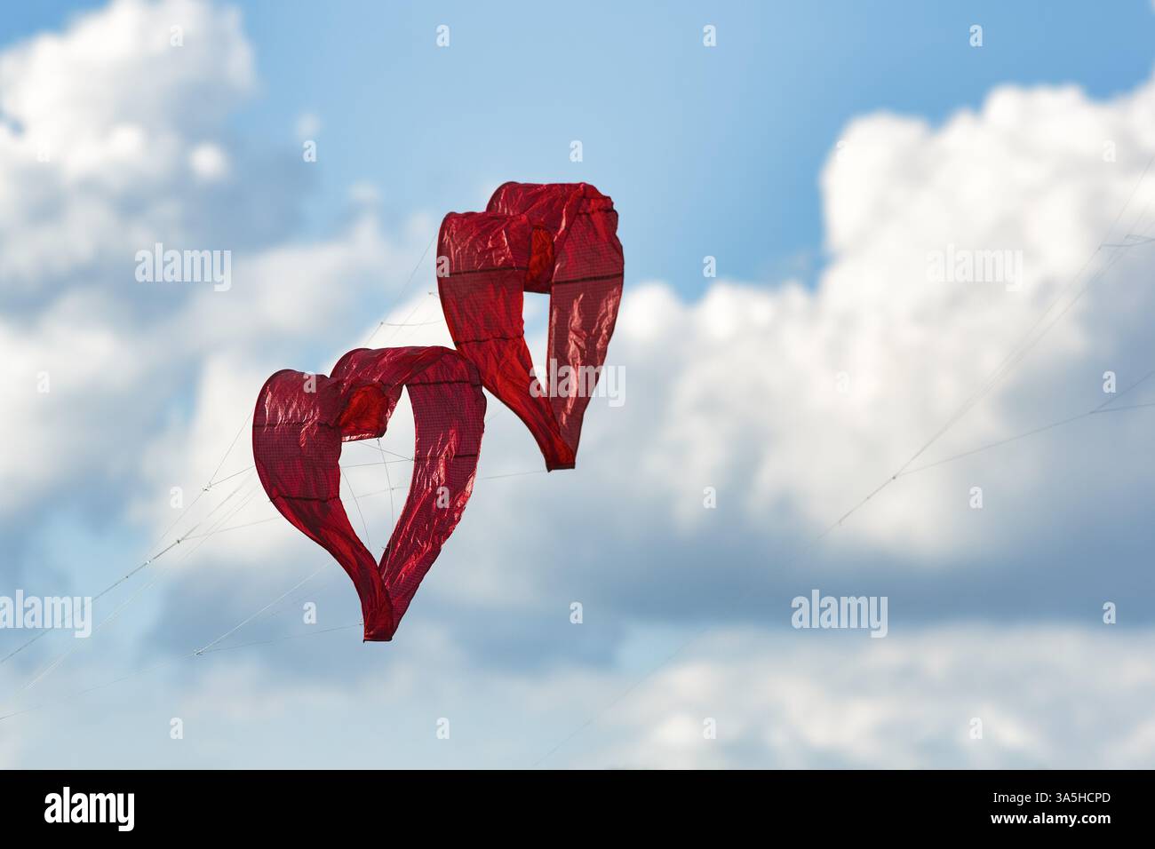 Two red heart-shaped kites flying side by side in the sky, text free ...