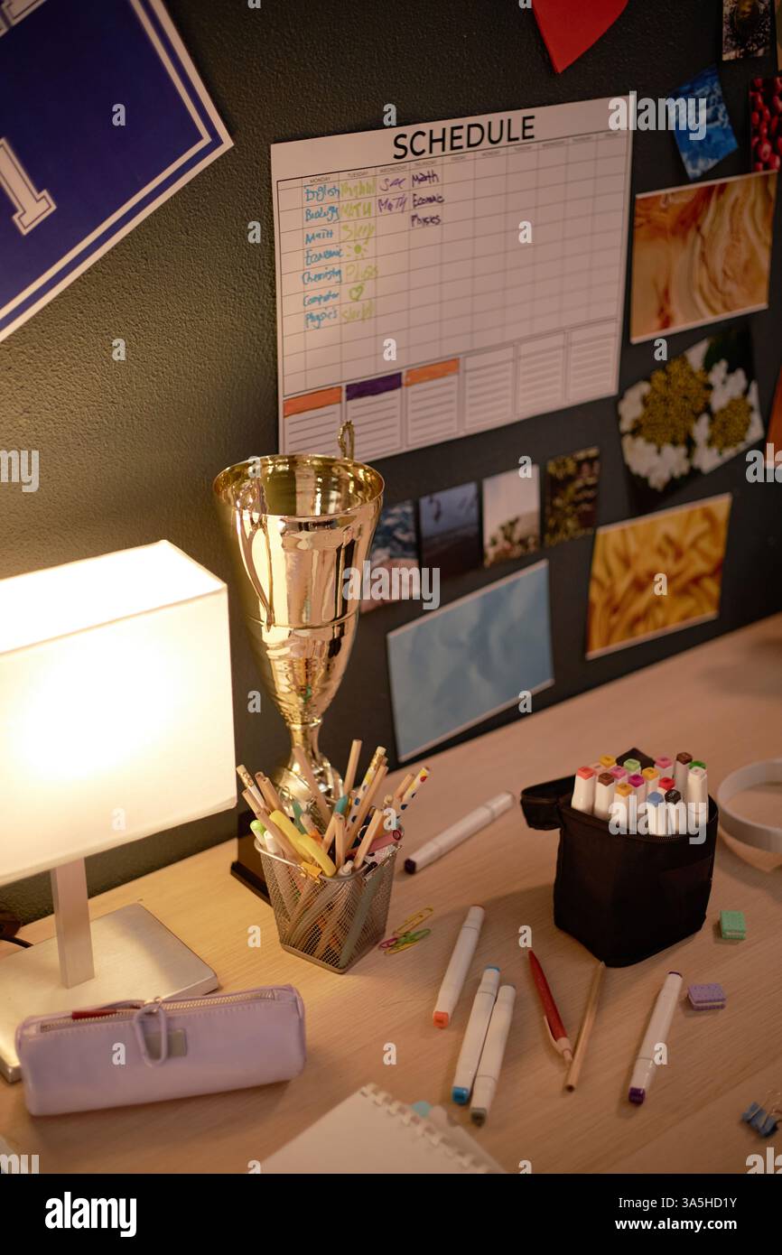 Neatly organized desk featuring trophy, study schedule, and various ...