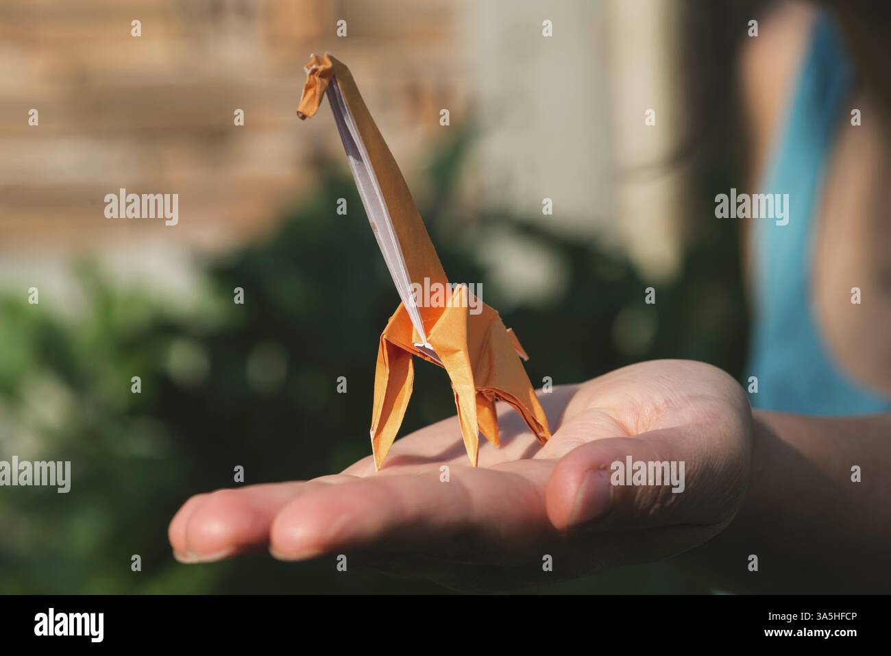 Origami orange color giraffe on hand Stock Photo - Alamy