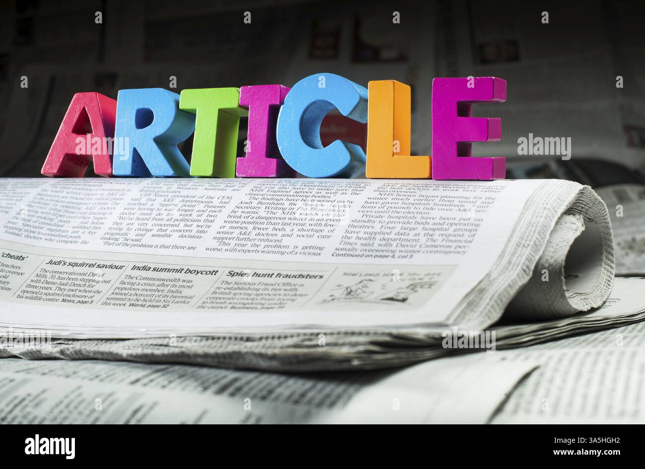 Word article on newspaper. Wooden letters Stock Photo - Alamy