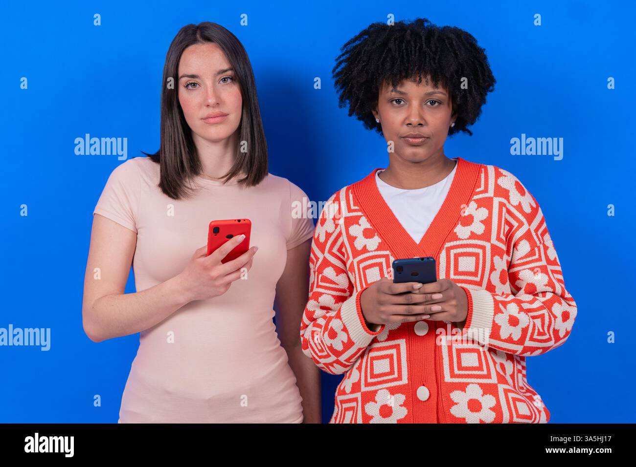 angry friends women using smartphones against a bright blue background ...