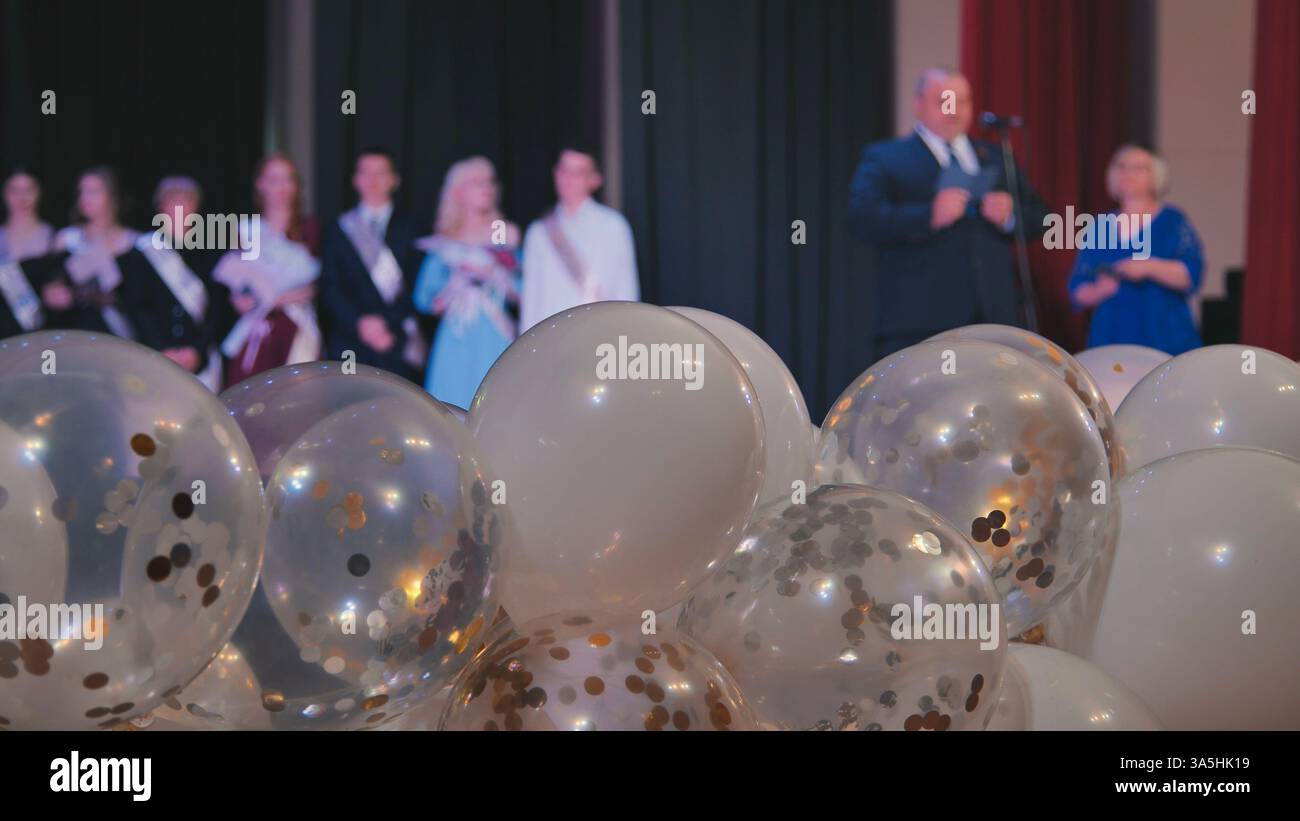Golden confetti filled white and transparent balloons floating near ...