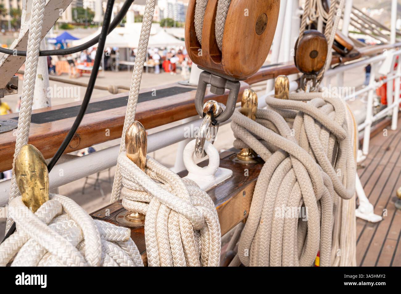 A boat has a number of ropes hanging from it. The ropes are white and ...