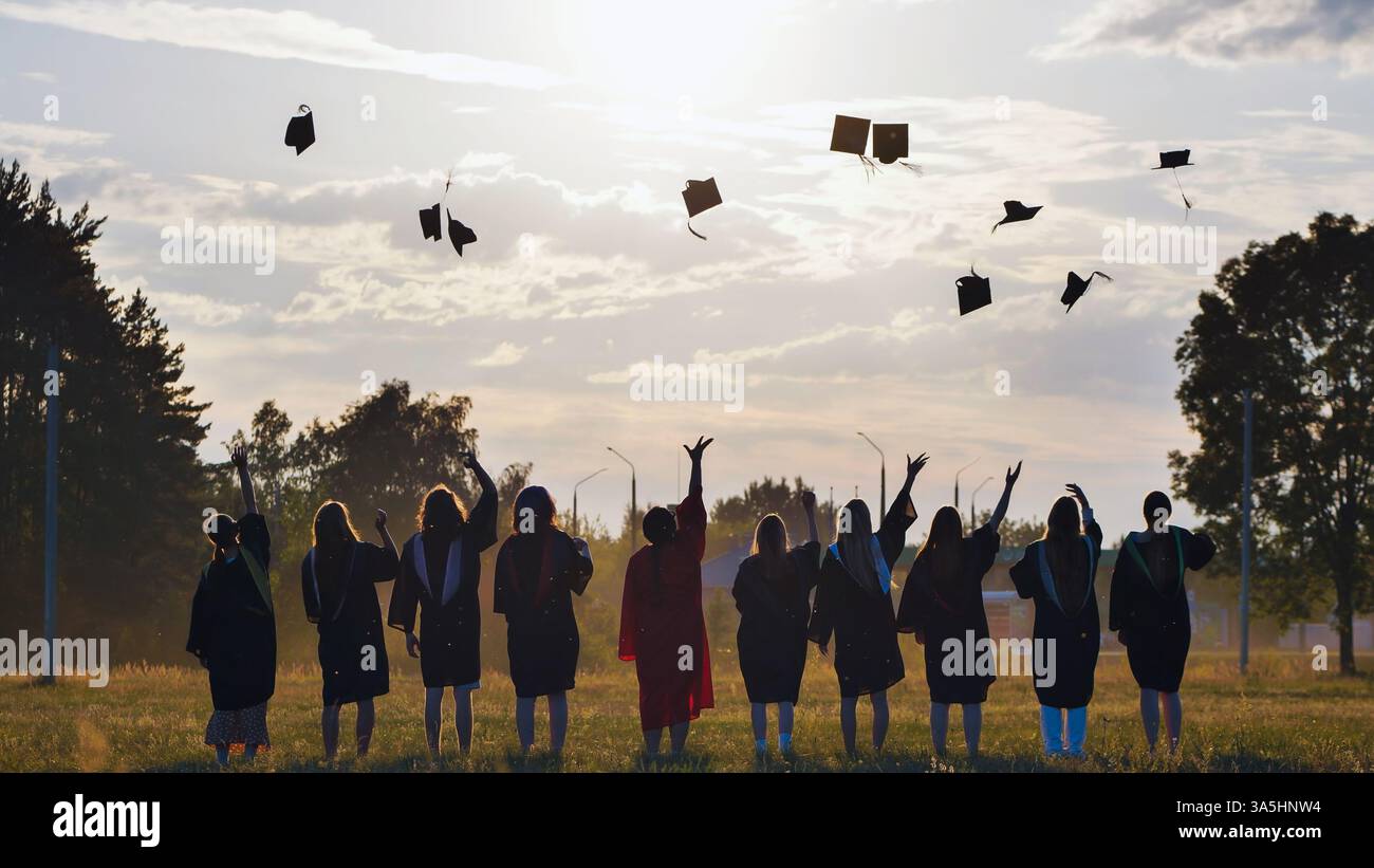 Happy students celebrating graduation by throwing their mortarboards in ...