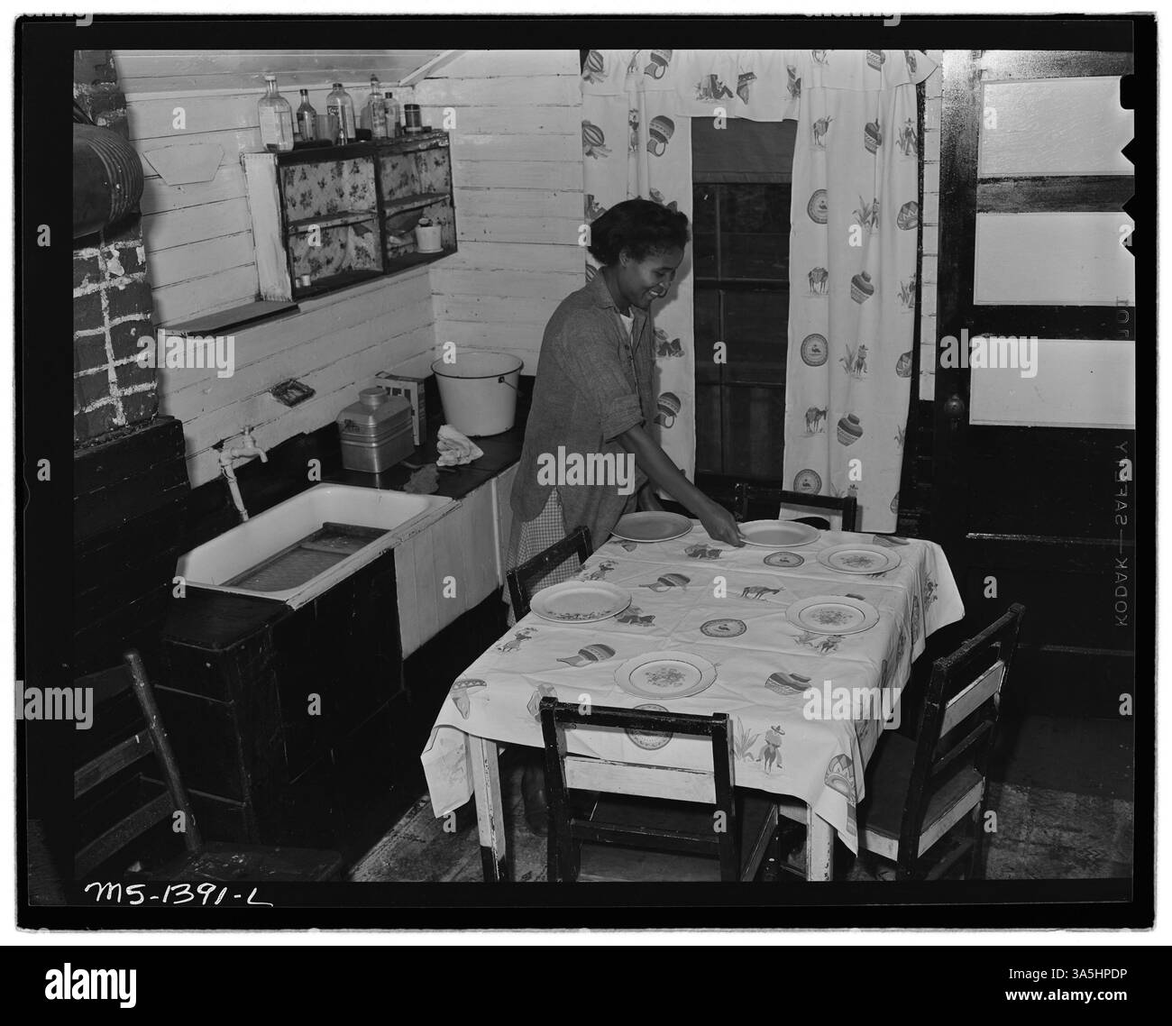 Mrs. James Robert Howard sets the table for supper in their home near ...