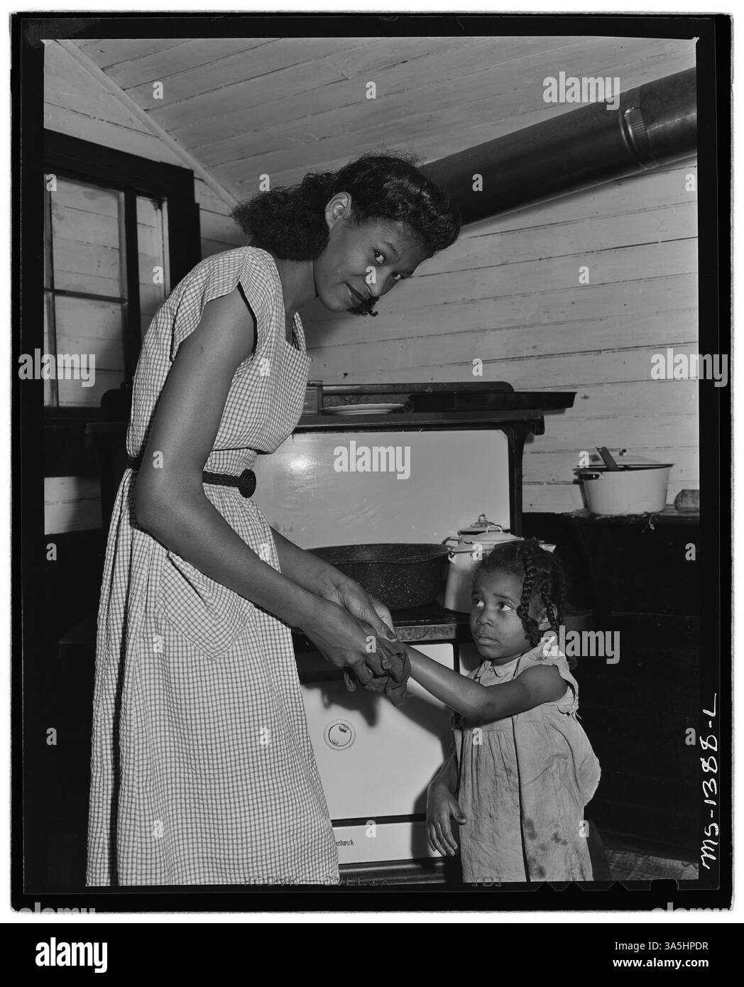 A visiting neighbor helps prepare the daughter of James Robert Howard ...