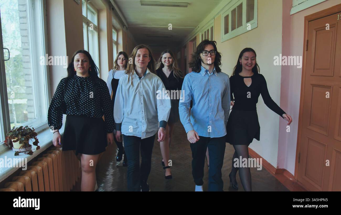 High school students happily strolling through the school hallway ...