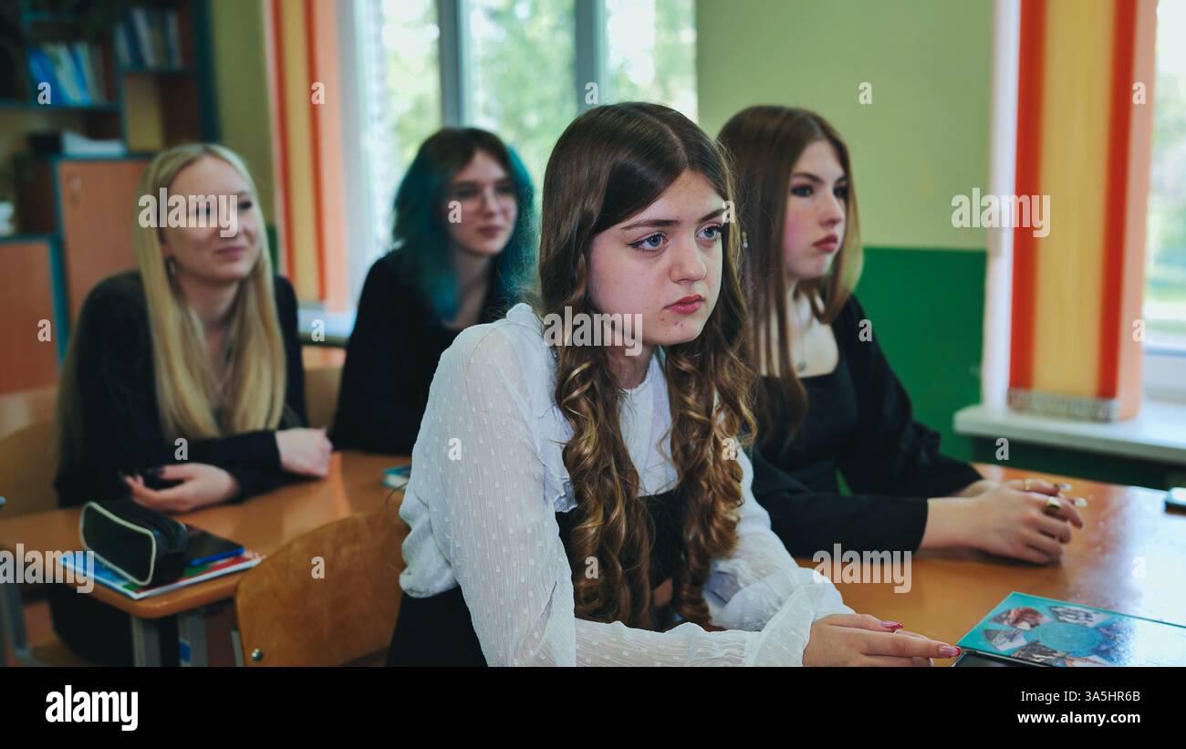Focused high school female students engaged in classroom lesson with ...