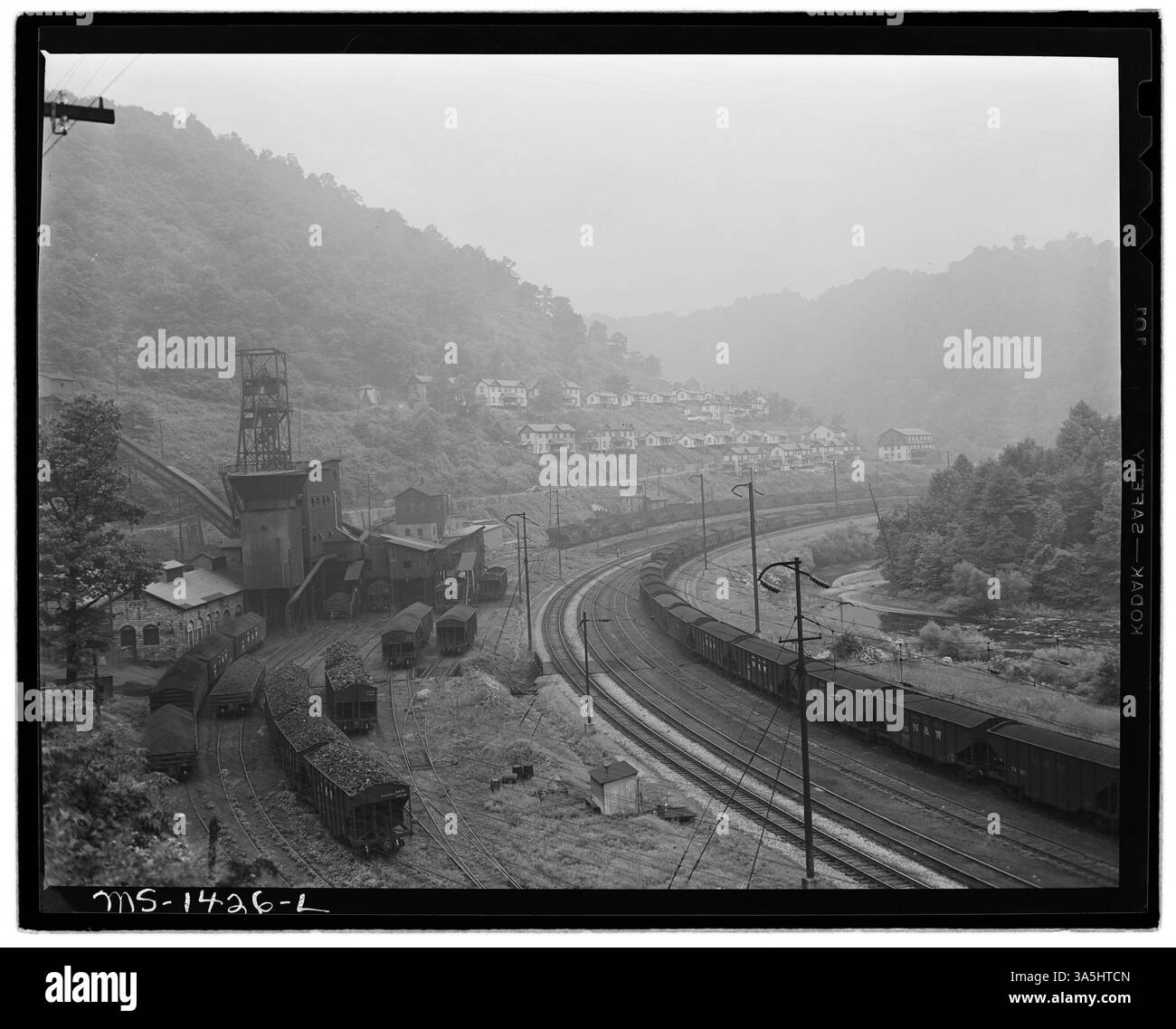A foggy morning view of the tipple, coal cars, and housing at New River ...
