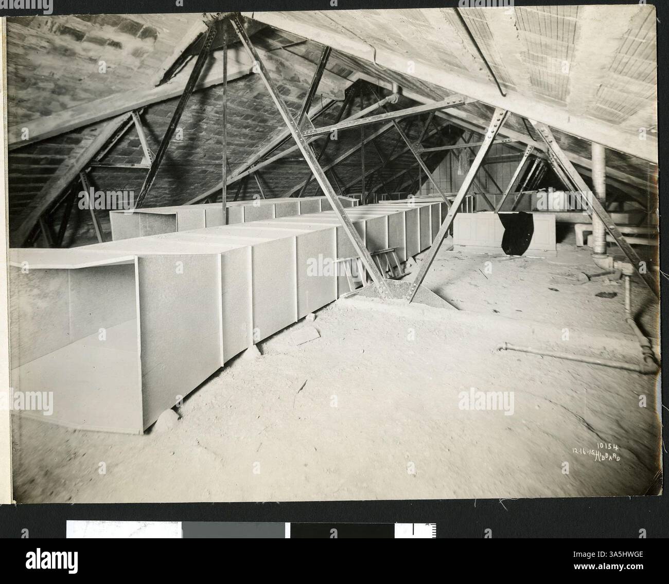A close-up view of the trusses, ducts, and roof structure in the attic ...
