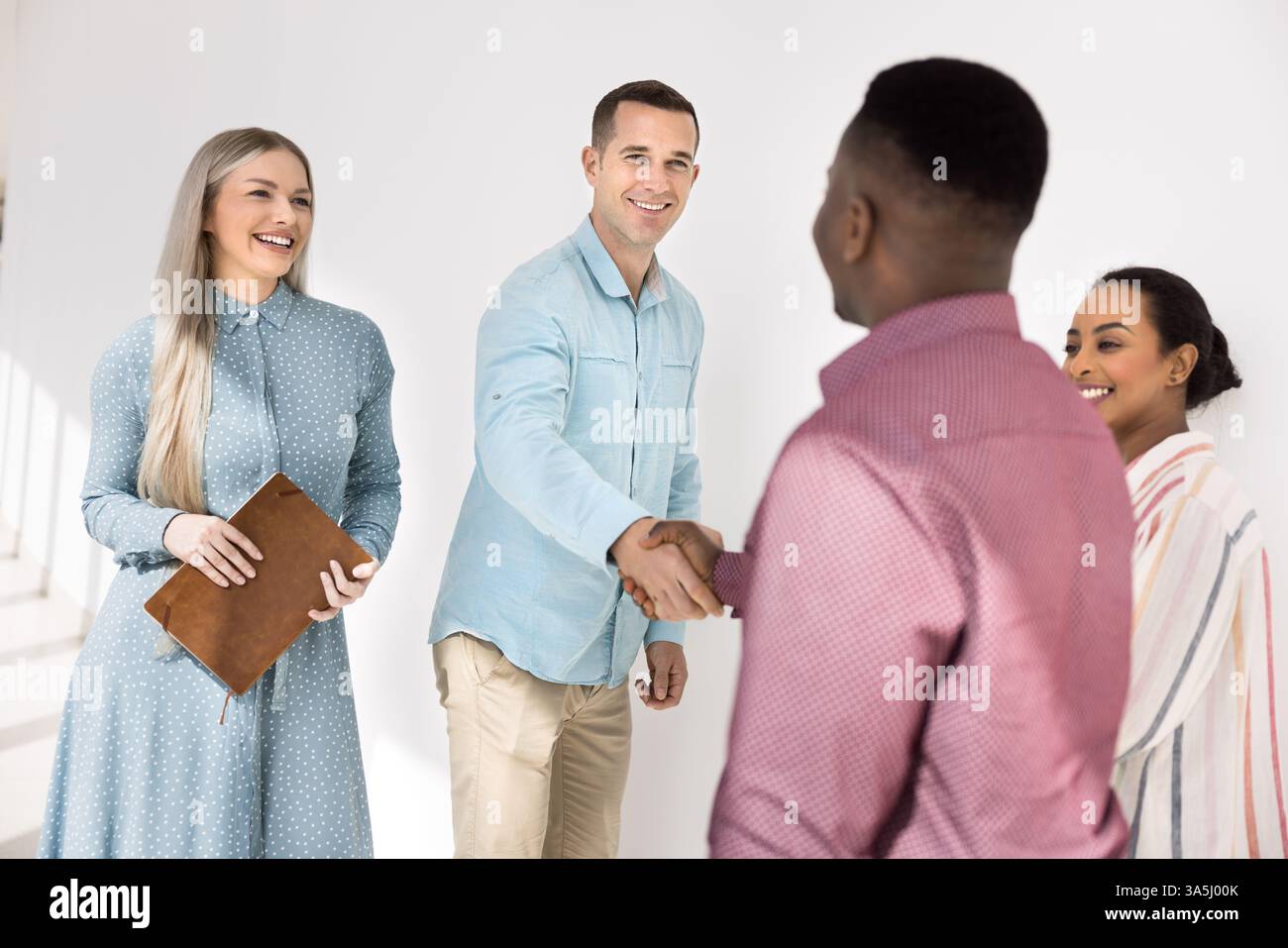 Group of young multiracial teammates met each other in corporate office ...