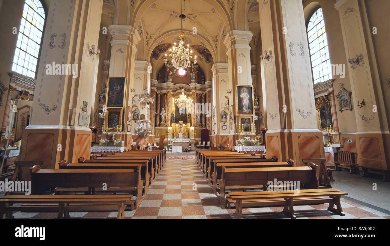 Interior of a church with wooden benches, altar, religious paintings ...