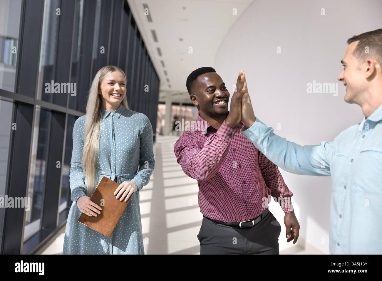 Two young 30s multiethnic male colleagues, buddies welcoming each other ...
