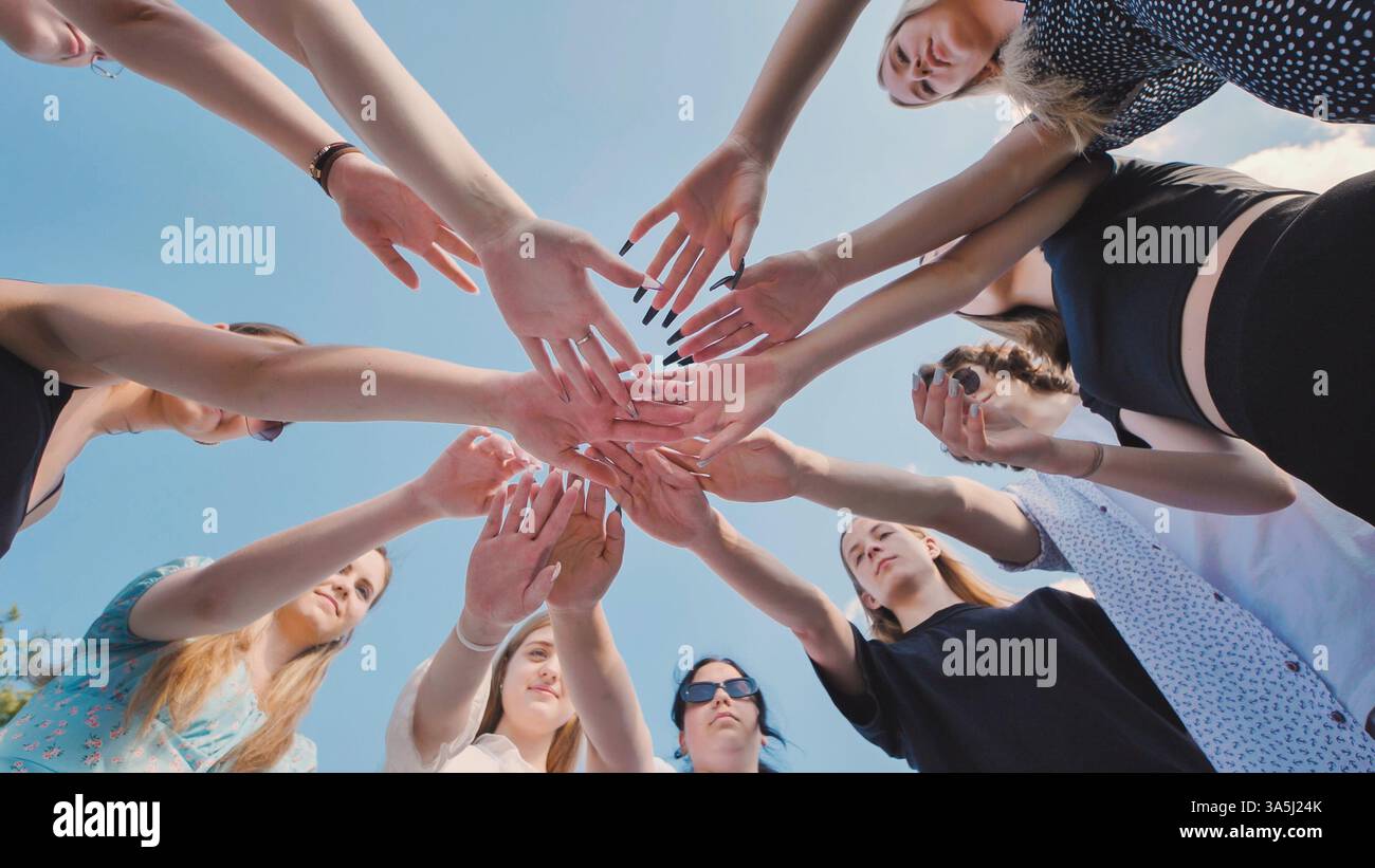 Group of friends forming a circle joining hands together outdoors in a sunny day Stock Photo - Alamy