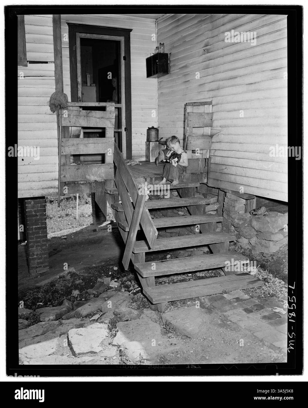 The son of Milong Bond, a tipple worker, stands on the back porch of ...