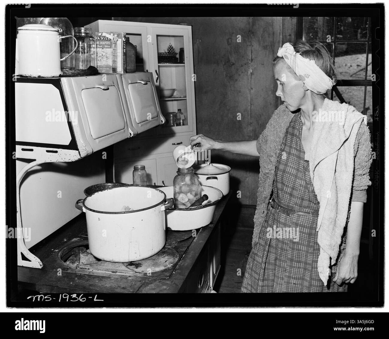 Mrs. Bill Daniels, wife of a coal miner, cans pears at her home near ...