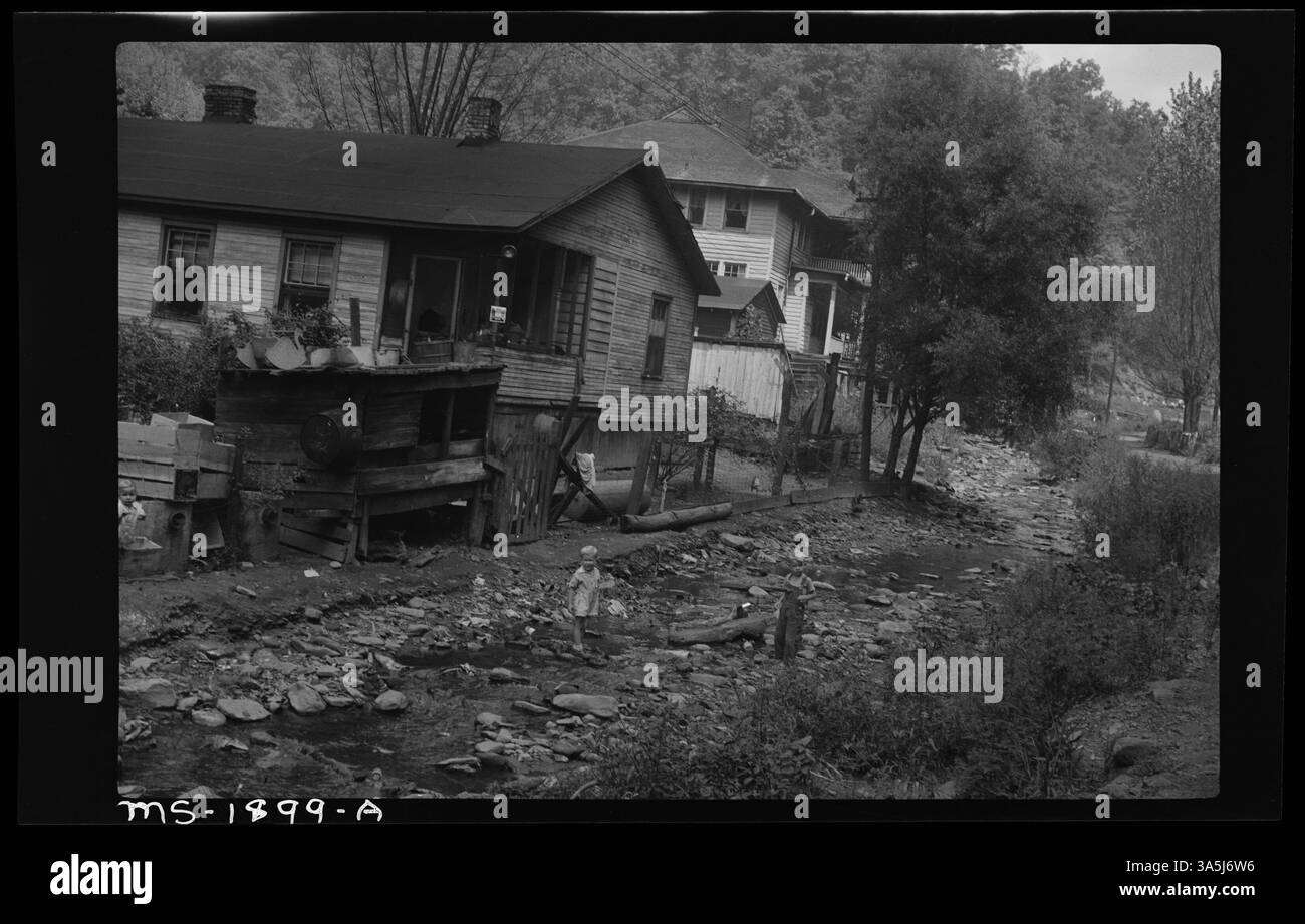 A child plays in a polluted stream near company-owned housing at ...