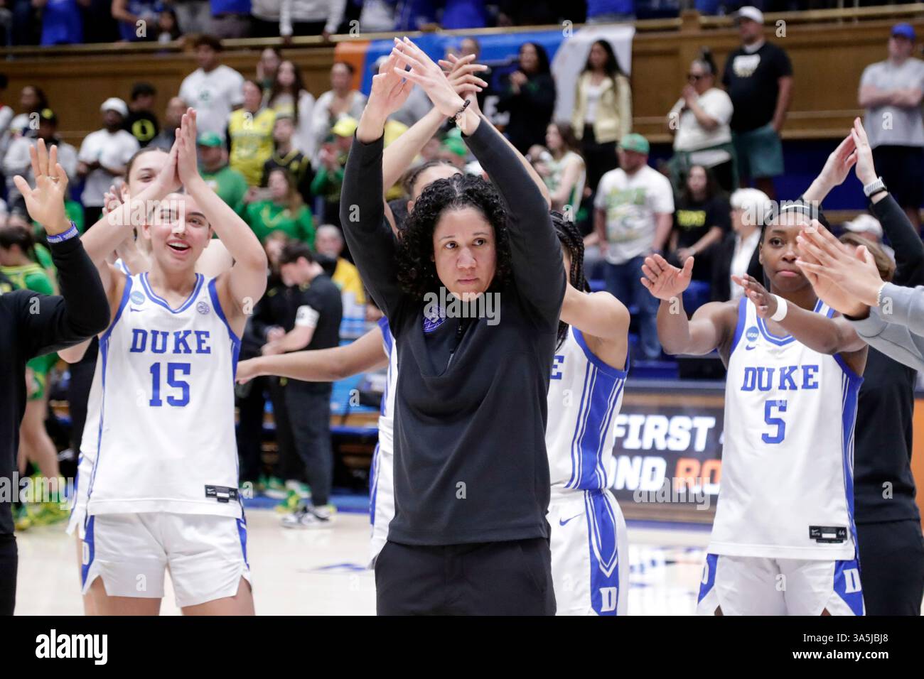 Duke head coach Kara Lawson, center, and her players celebrate after they defeated Oregon in the ...