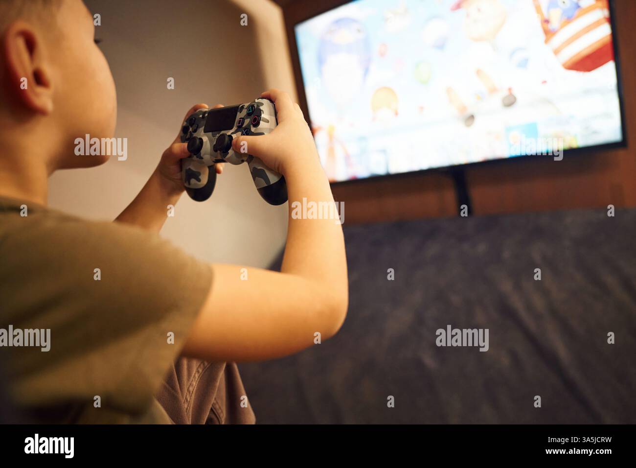 Boy is playing console game, holding joystick controller Stock Photo ...
