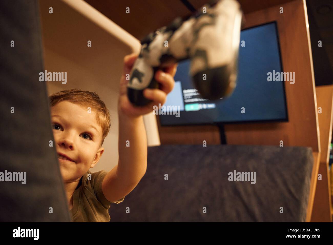 Boy is playing console game, holding joystick controller Stock Photo ...