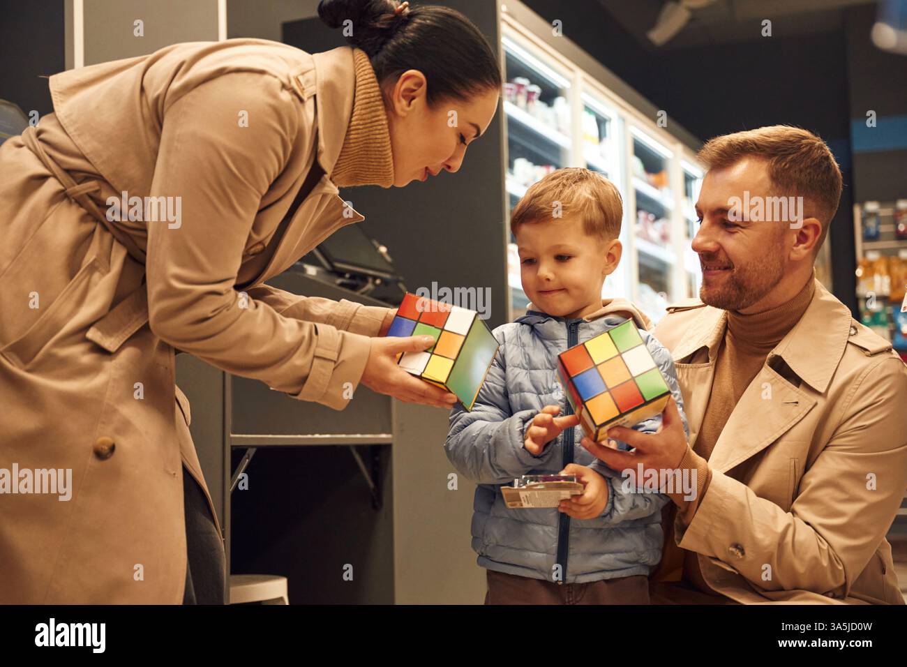 Family is in the toy shop, holding Rubik's cube Stock Photo - Alamy