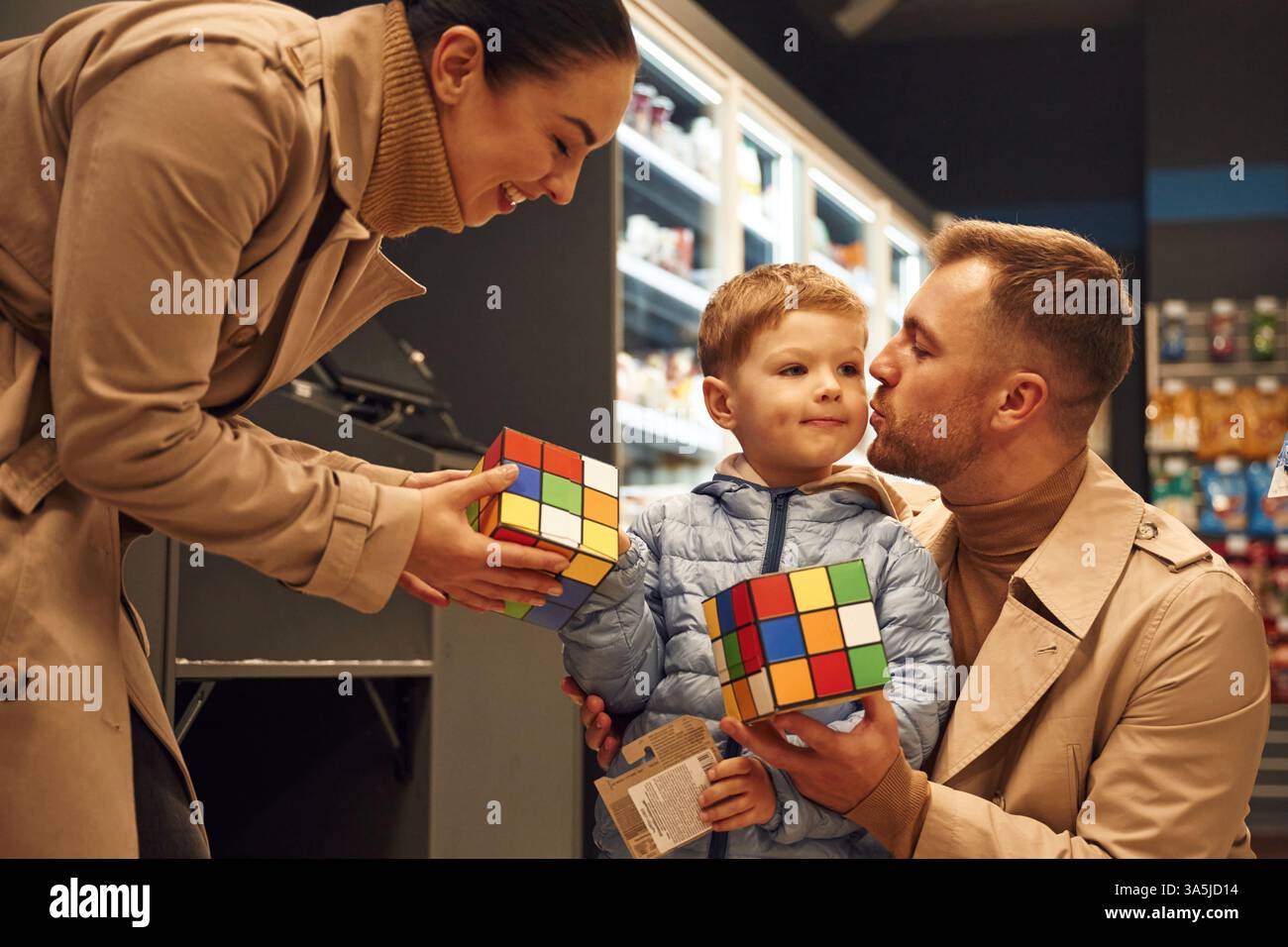 Family is in the toy shop, holding Rubik's cube Stock Photo - Alamy