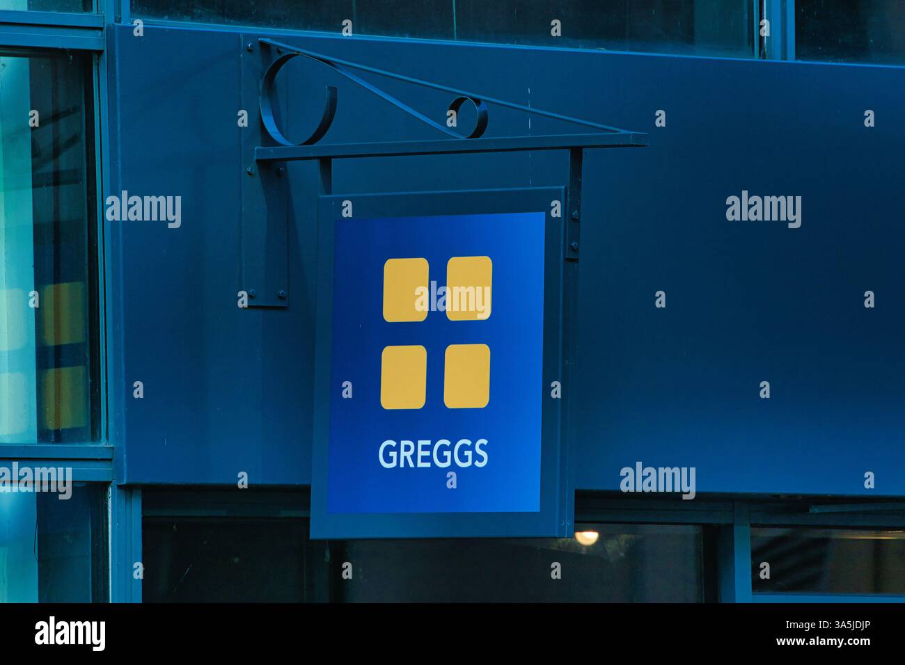 Greggs sign attached to a blue building exterior. The sign features ...