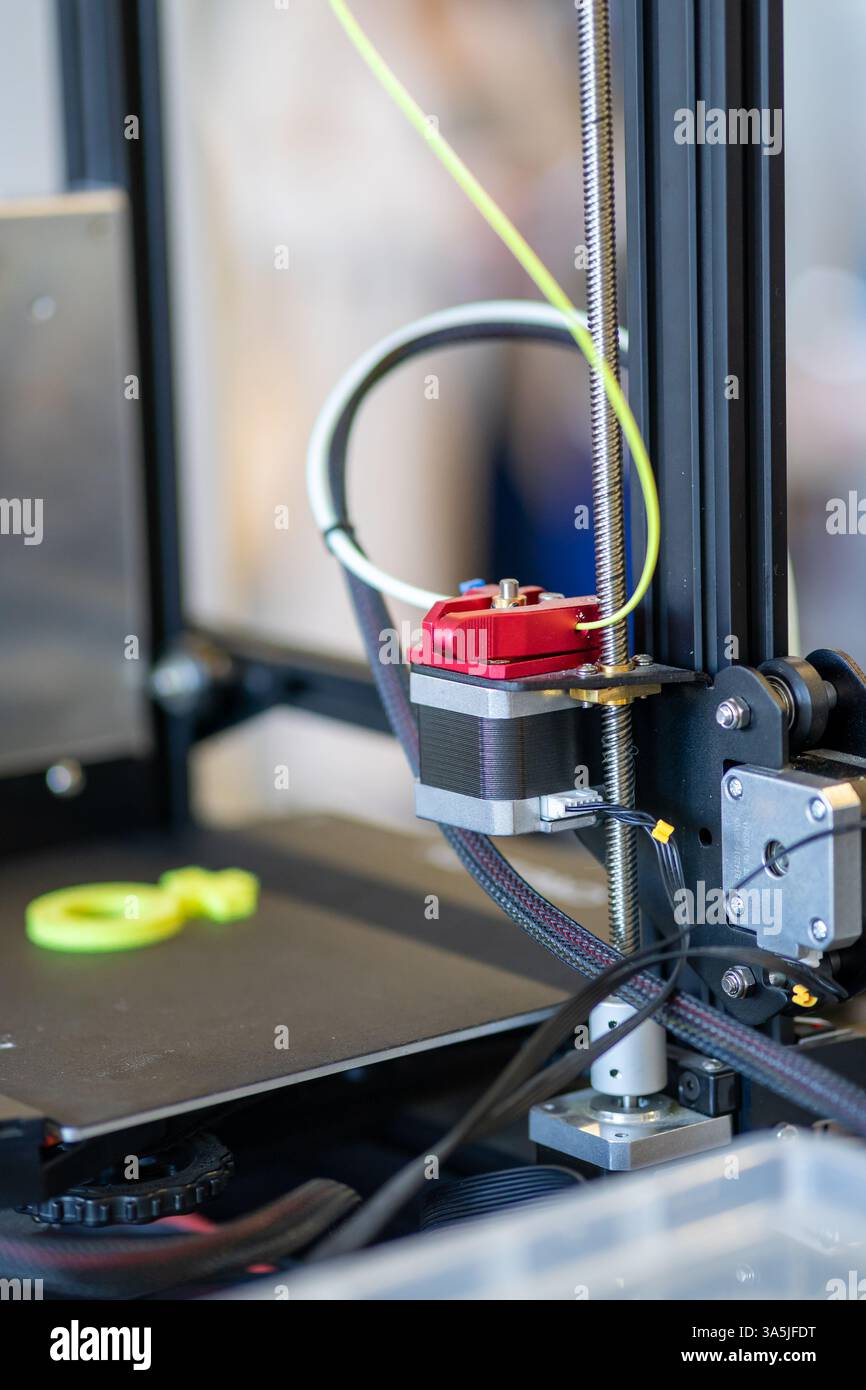 View of a part of a 3D printer printing a green symbol from plastic ...