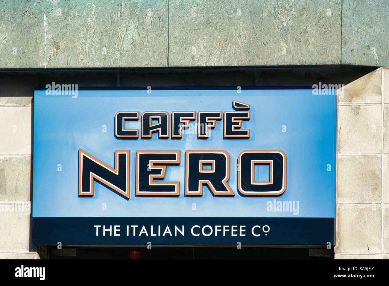 A sign for Caffè Nero. Blue background with black and brown lettering ...