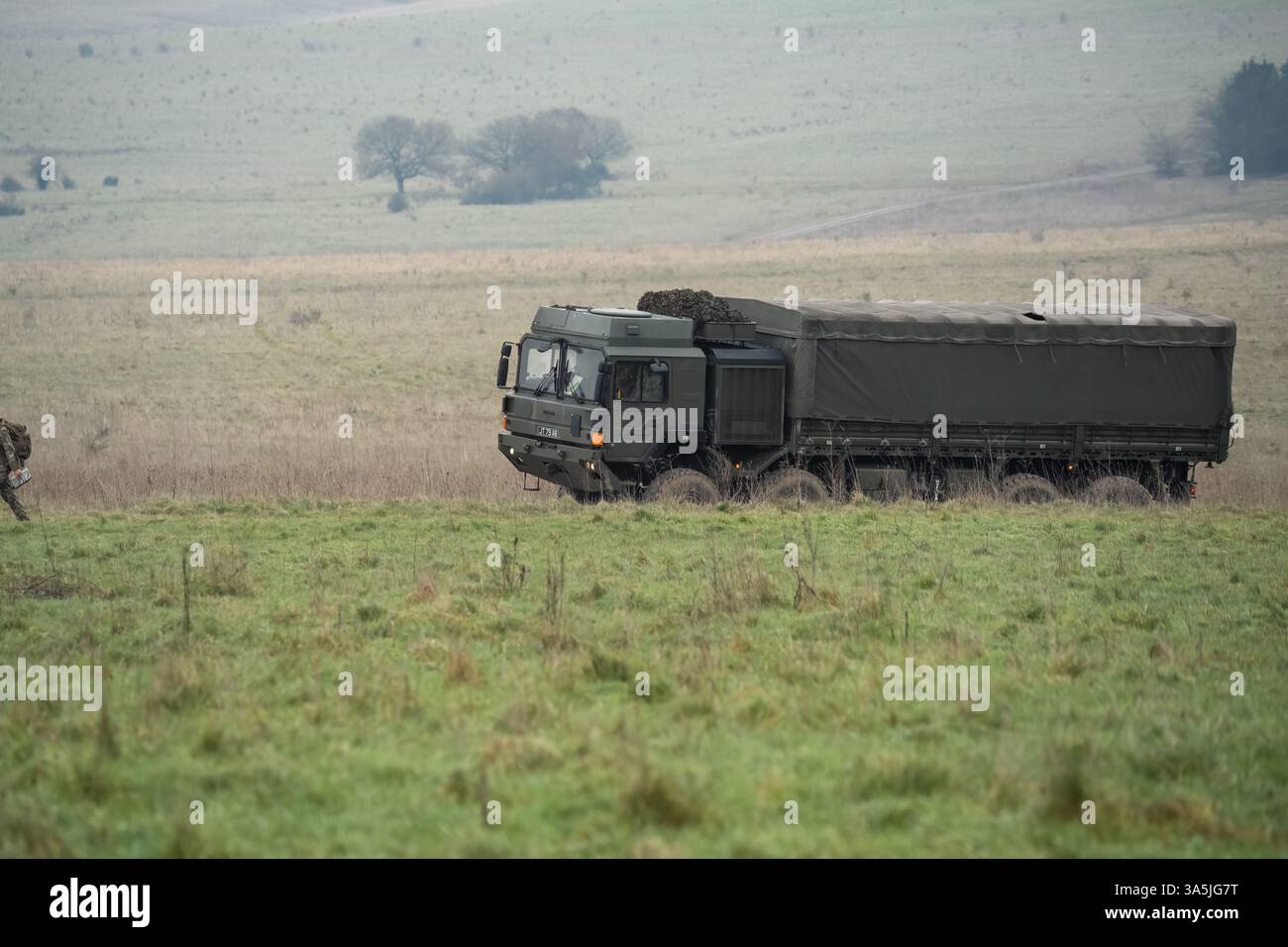 British army MAN SV HX 8x8 utility truck moving along a country track ...