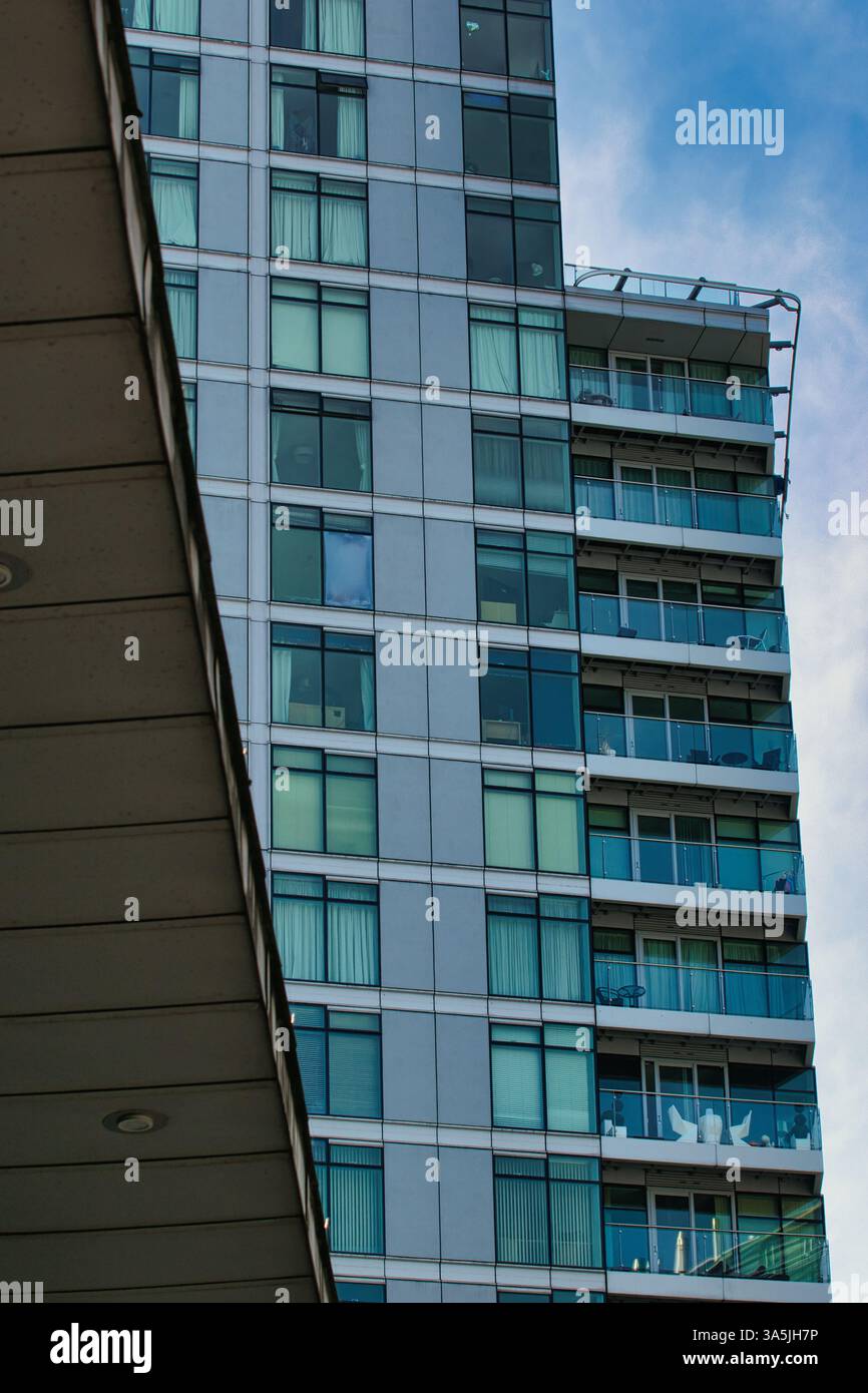 Partial view of a tall, modern building with balconies and many windows ...