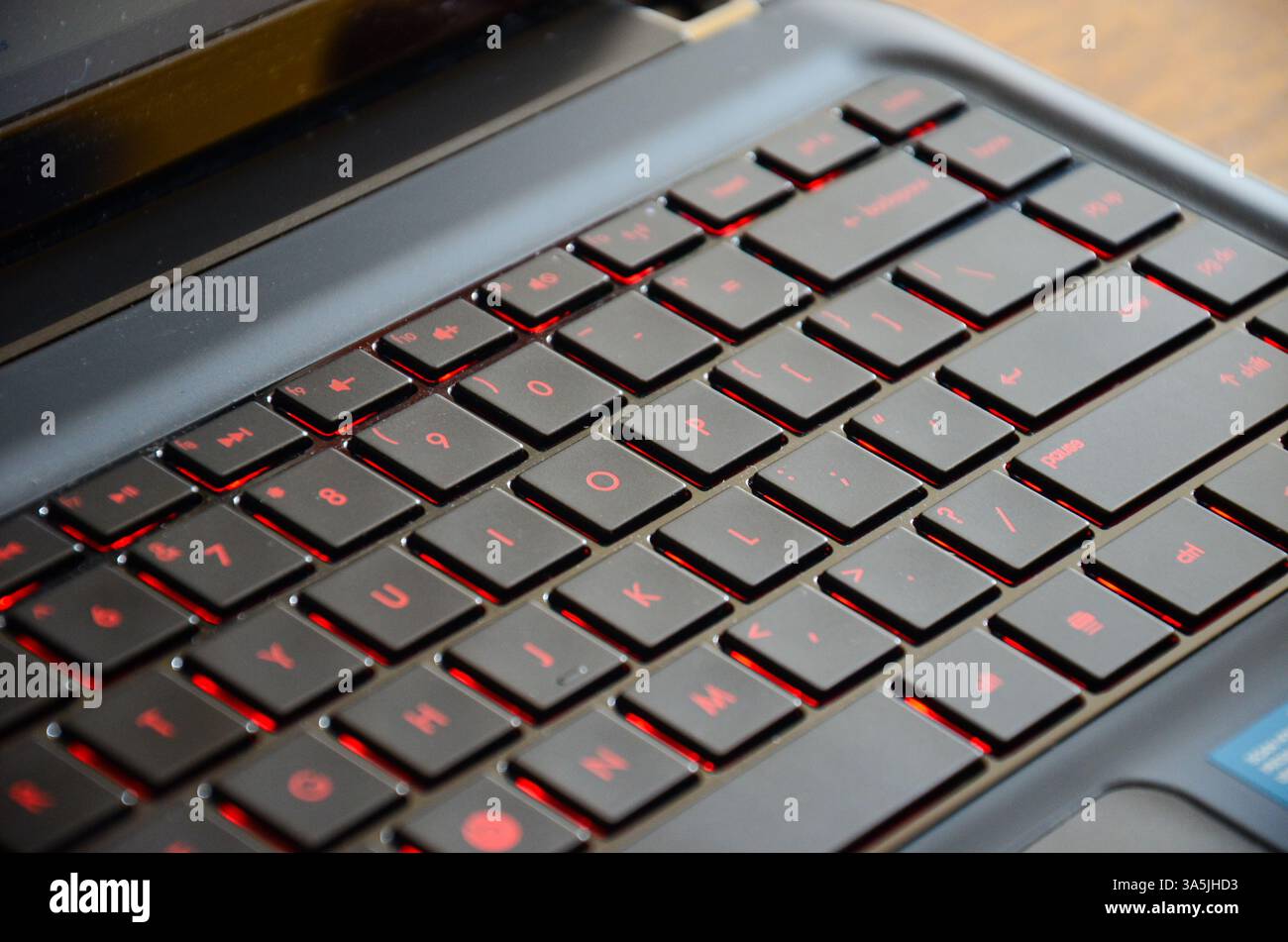 Close-up of sleek laptop keyboard with red backlit keys on modern ...