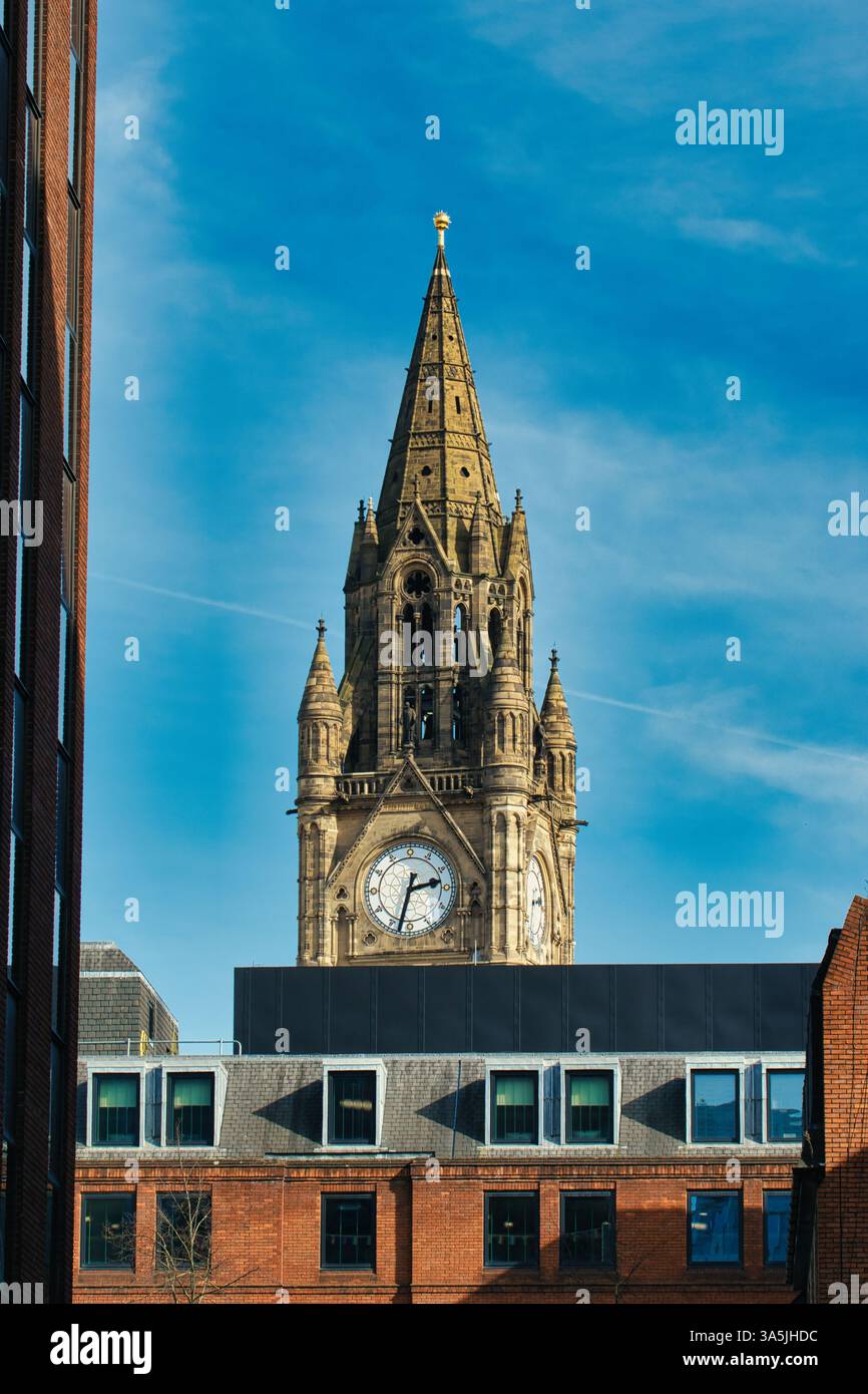 Clock tower rising above buildings under a blue sky. Gothic ...