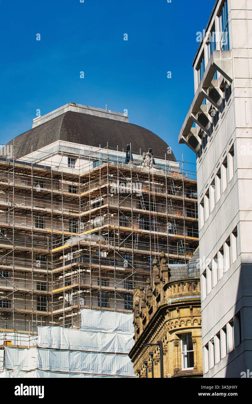 A tall building covered in scaffolding with a dome-shaped roof ...