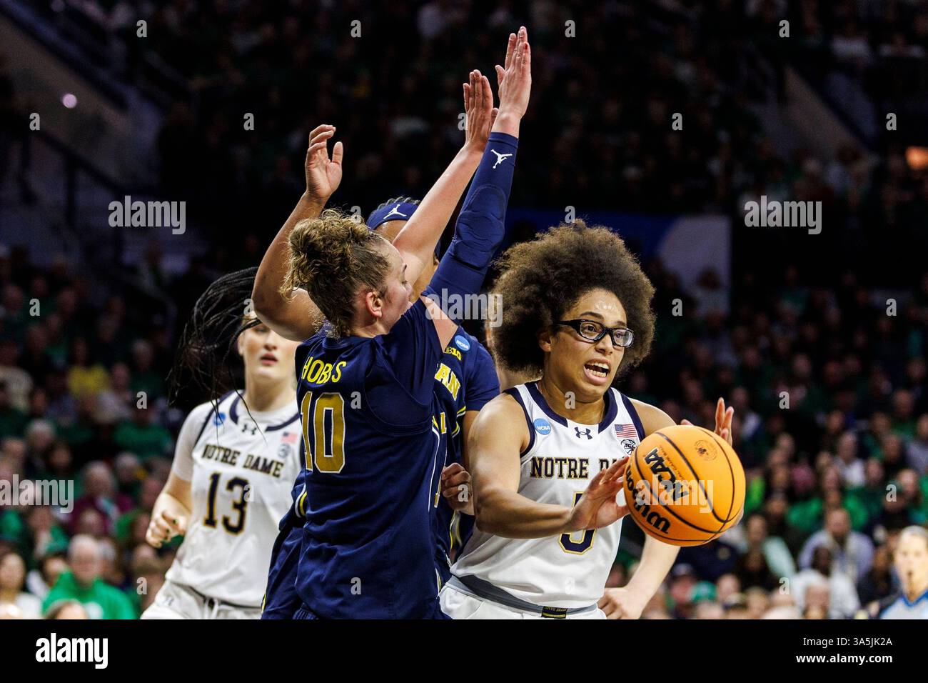 Notre Dame guard Olivia Miles, right, passes the ball as Michigan guard ...